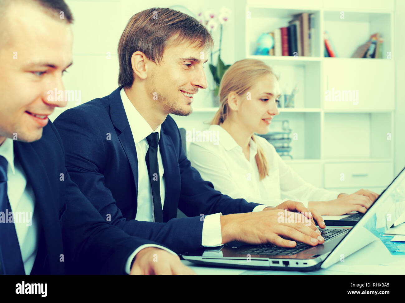 Glad business male assistant wearing formalwear using laptop and ...