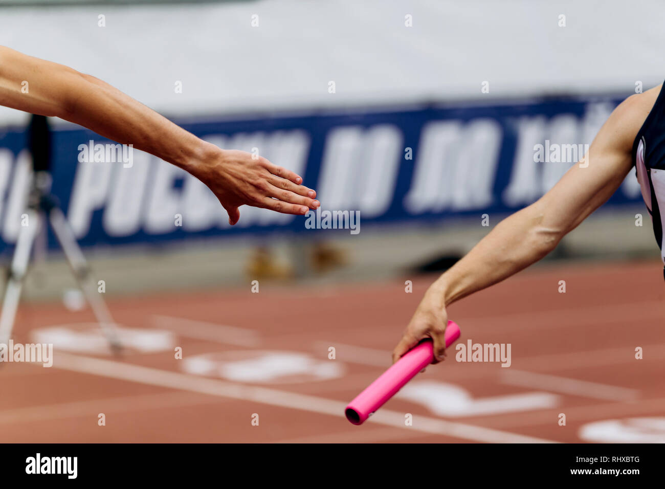 relay race racing hands men runners passing of baton Stock Photo - Alamy