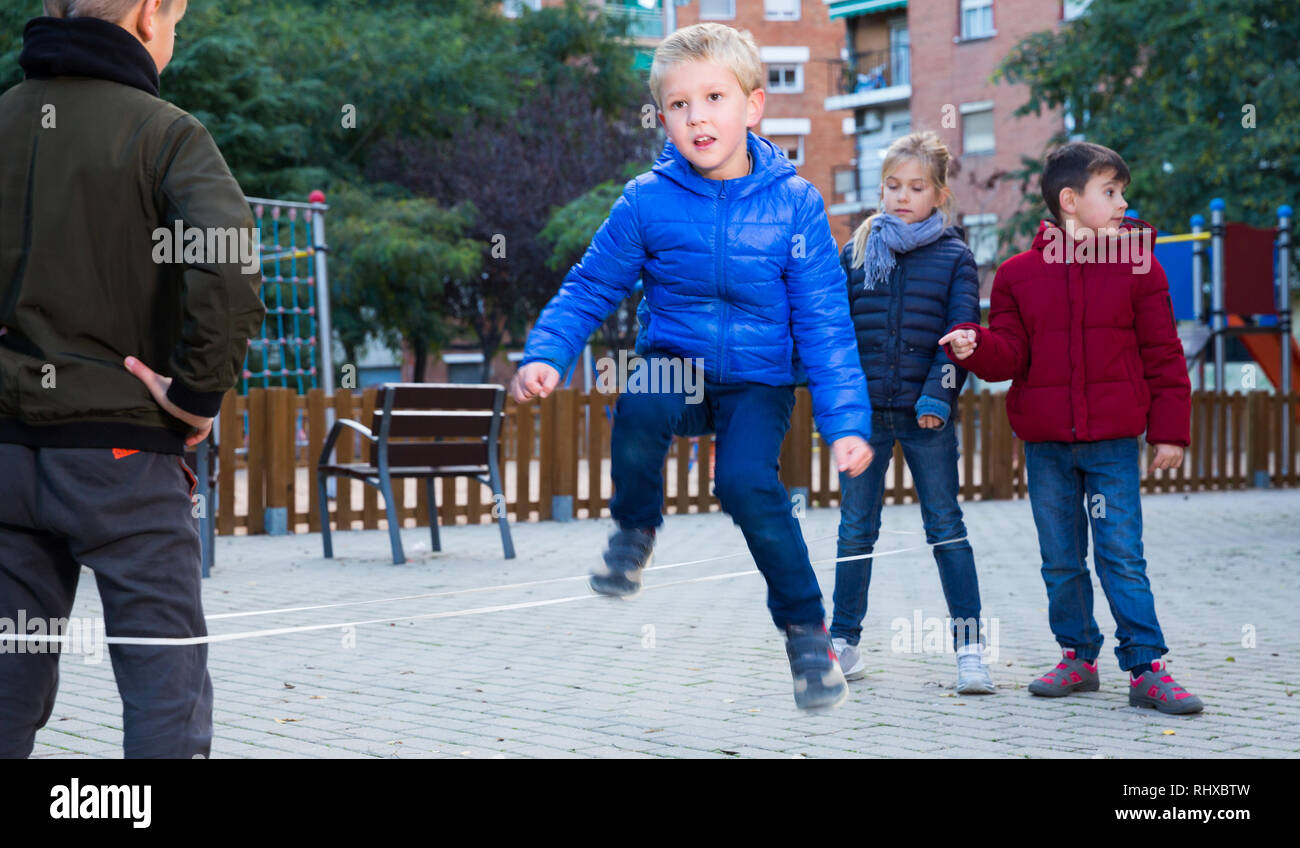 Children jump through an elastic rope in a children playground Stock ...