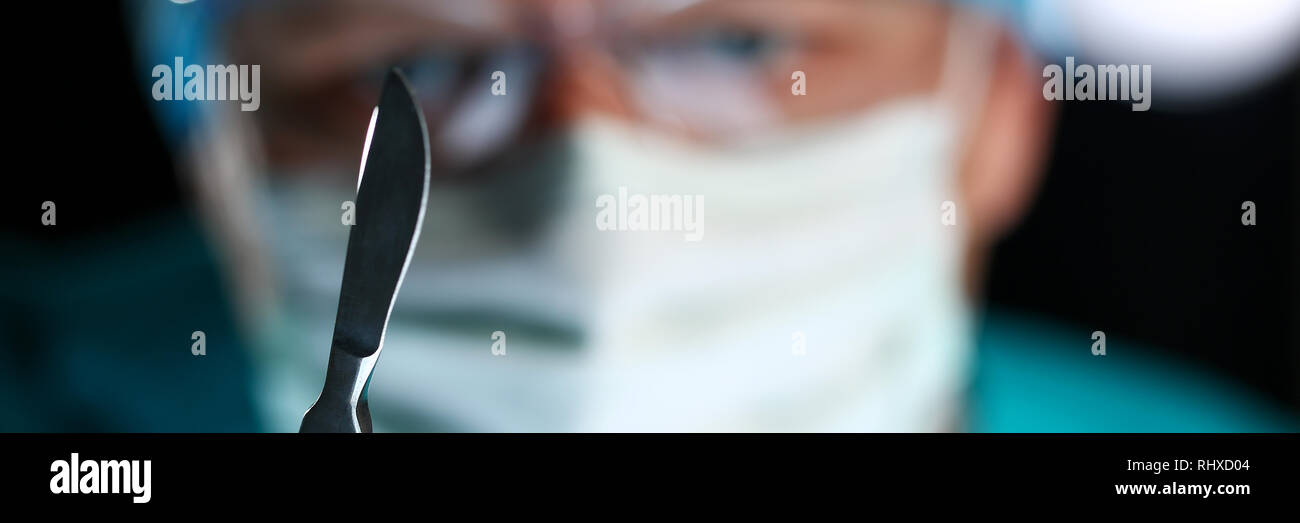 Surgeon arms in sterile uniform holding sharp knife Stock Photo - Alamy