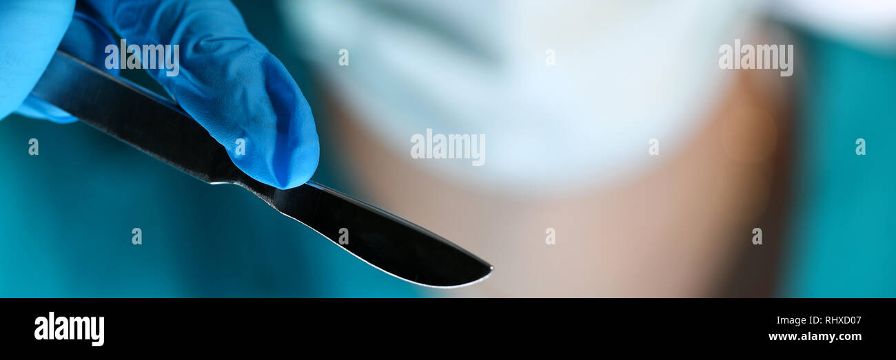 Surgeon arms in sterile uniform holding sharp knife Stock Photo - Alamy