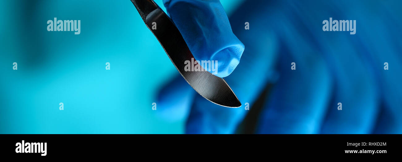 Surgeon arms in sterile uniform holding sharp knife Stock Photo - Alamy