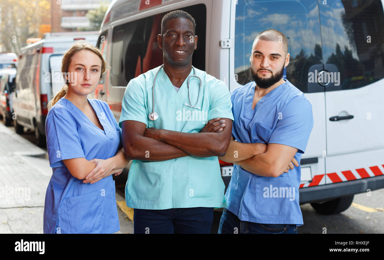 Portrait of positive friendly smiling efficient ambulance team of three ...