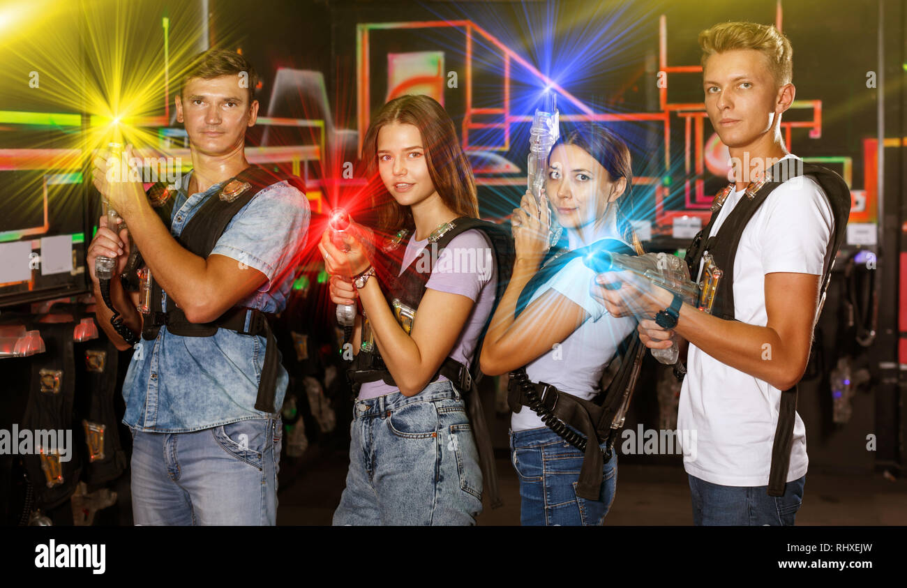 Group portrait of young people with laser guns having fun together in ...