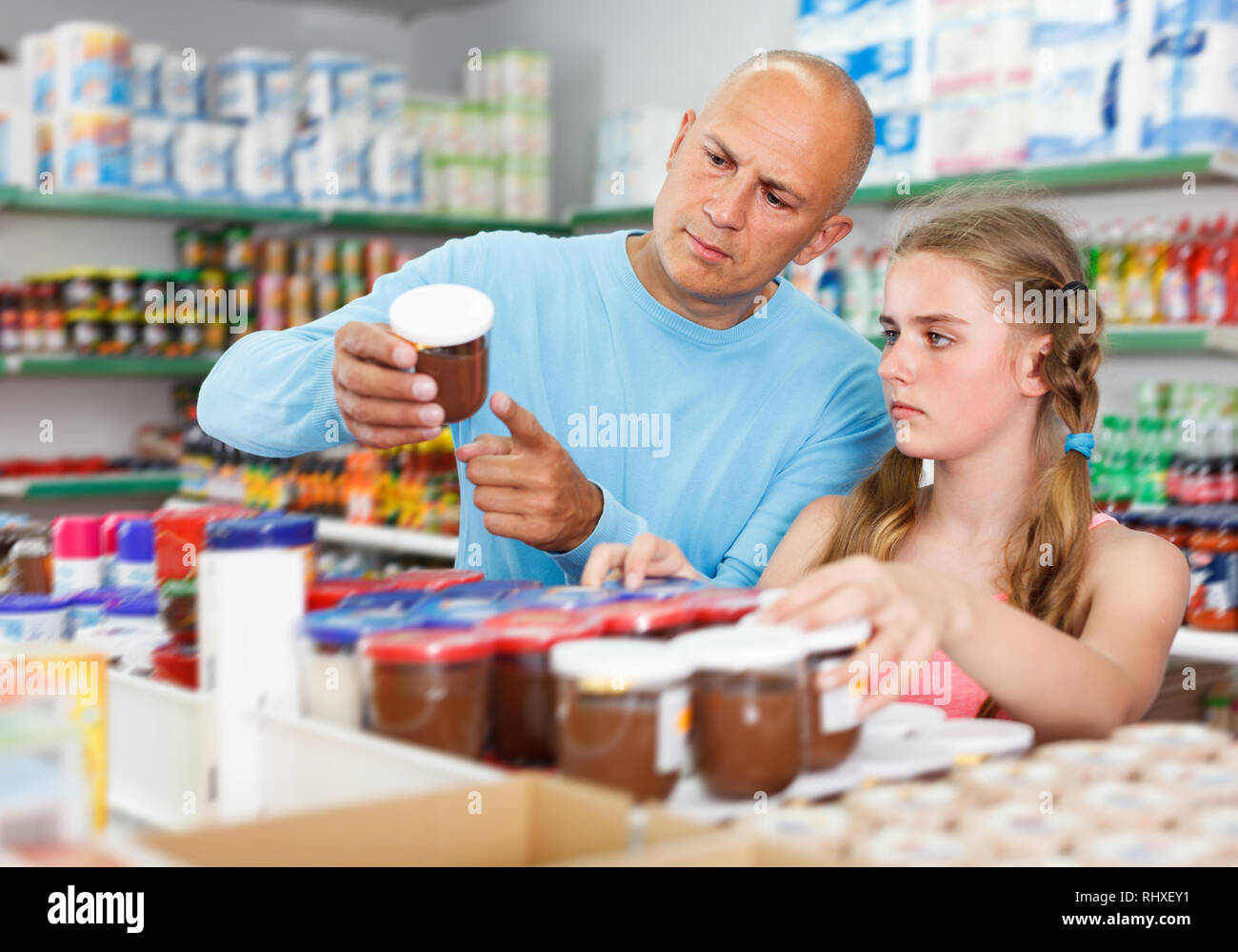 positive father doing shopping with preteen girl in food department of ...