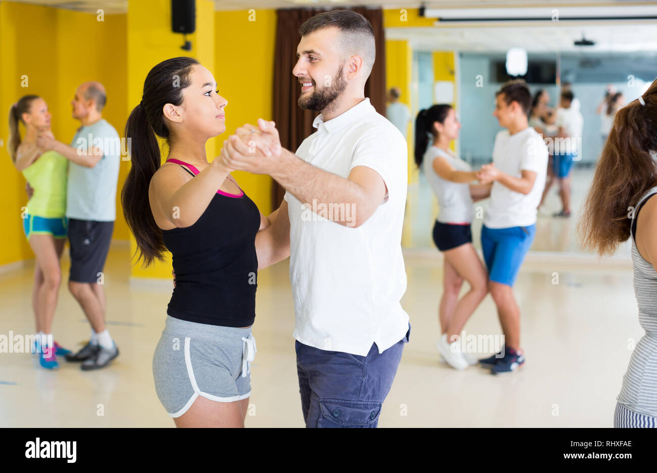 Smiling dancing couples learning salsa at dance class Stock Photo - Alamy