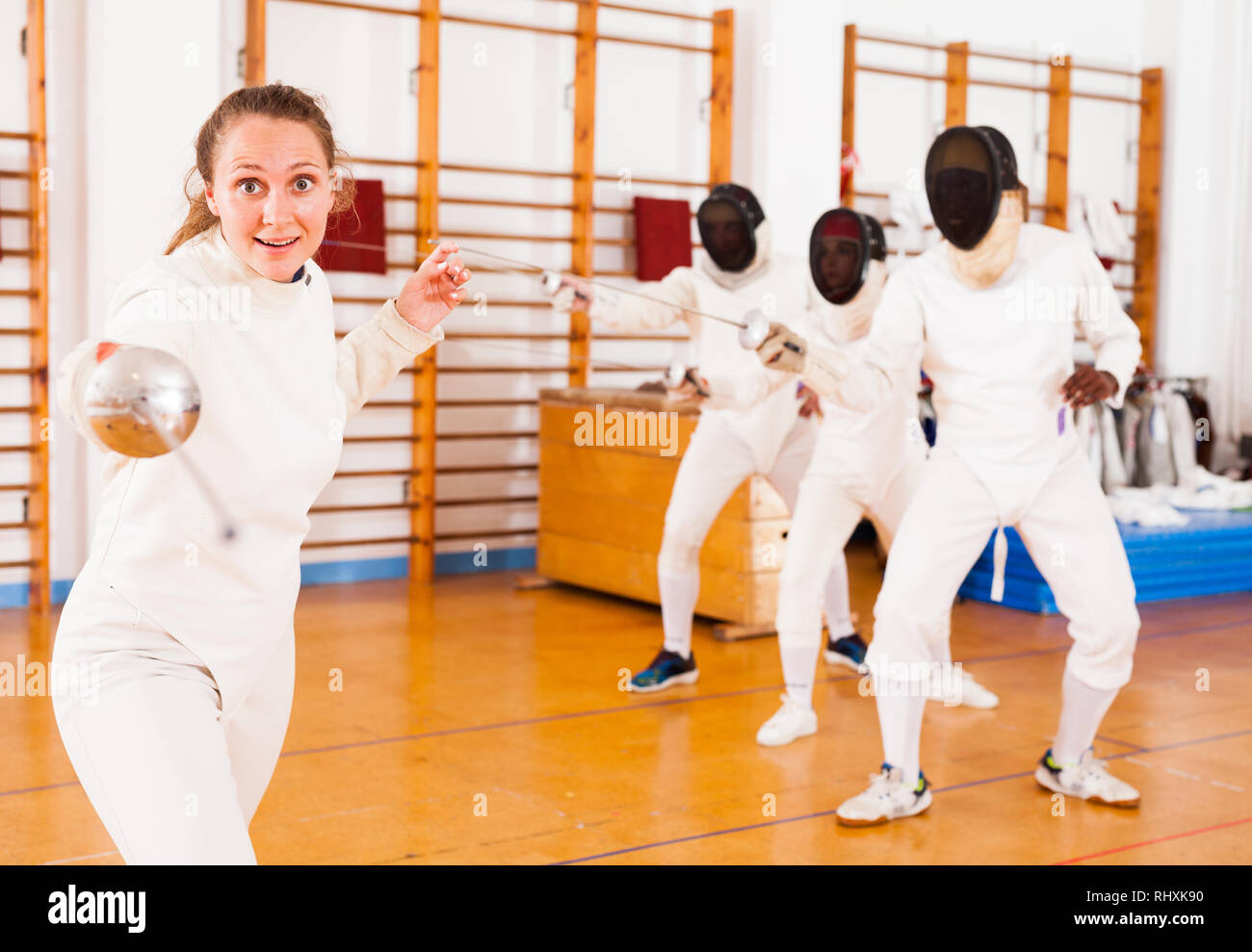 Sporty young female fencer practicing fencing technique in training ...