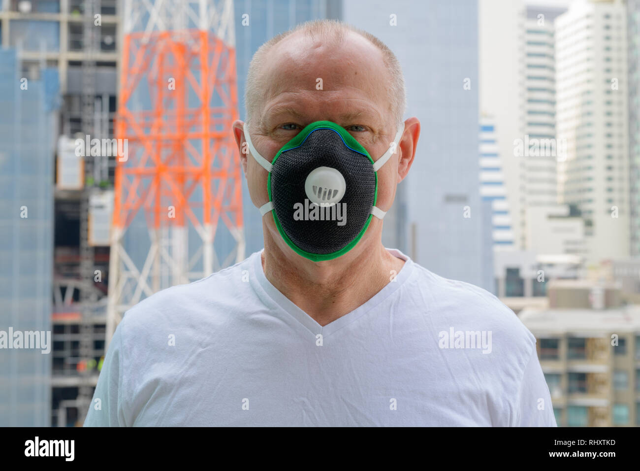 Senior man using face mask to protect from pollution smog in city Stock ...
