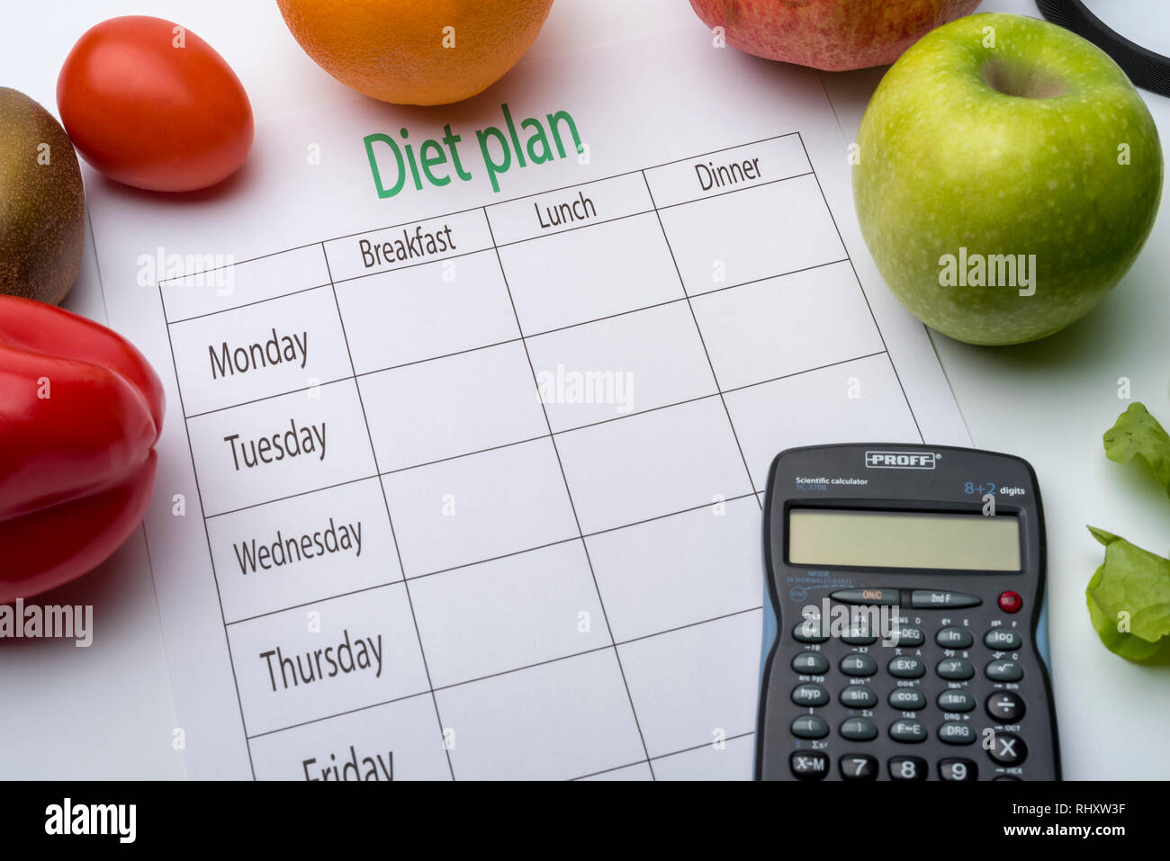 Diet plan sheet and fresh food on white background. Top view, the ...