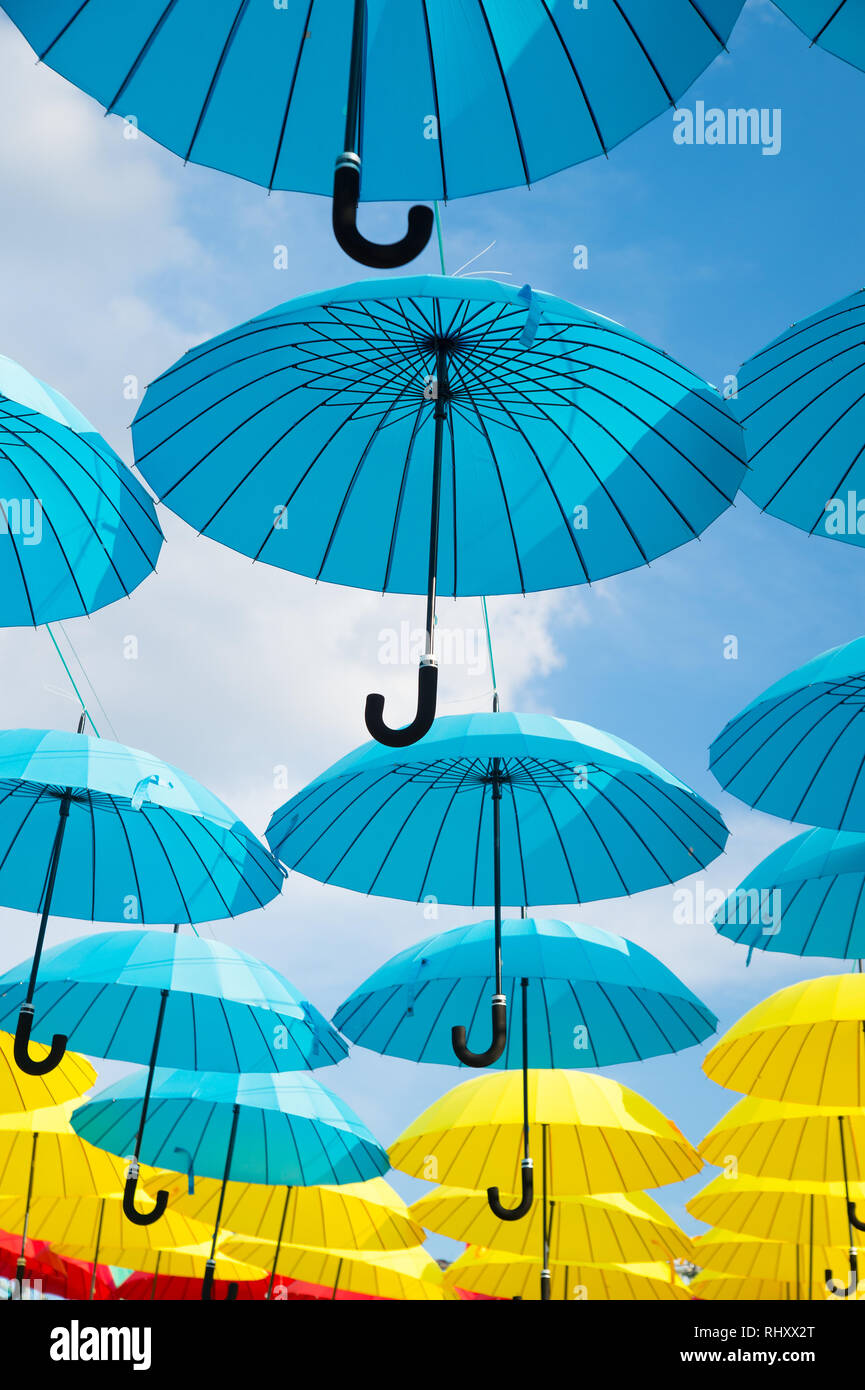 Outdoor art design and decor. Umbrellas float in sky on sunny day ...