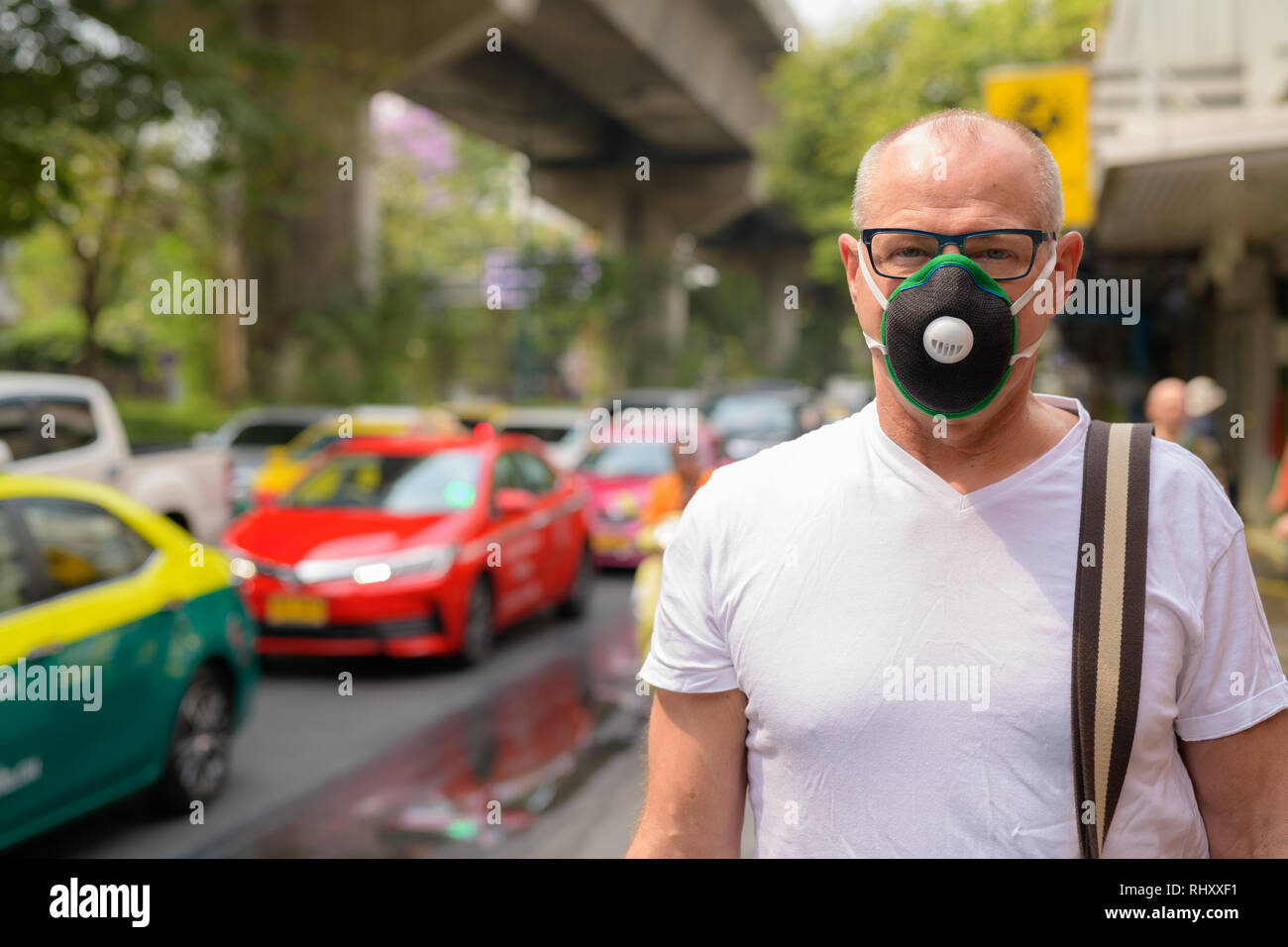 Senior man using face mask to protect from pollution smog in city Stock ...