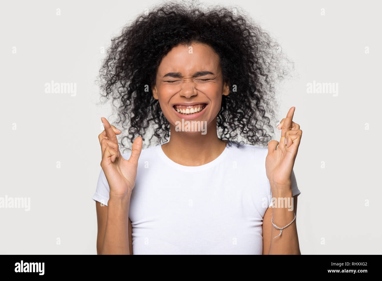 Funny superstitious black woman crossing fingers wishing for good luck ...