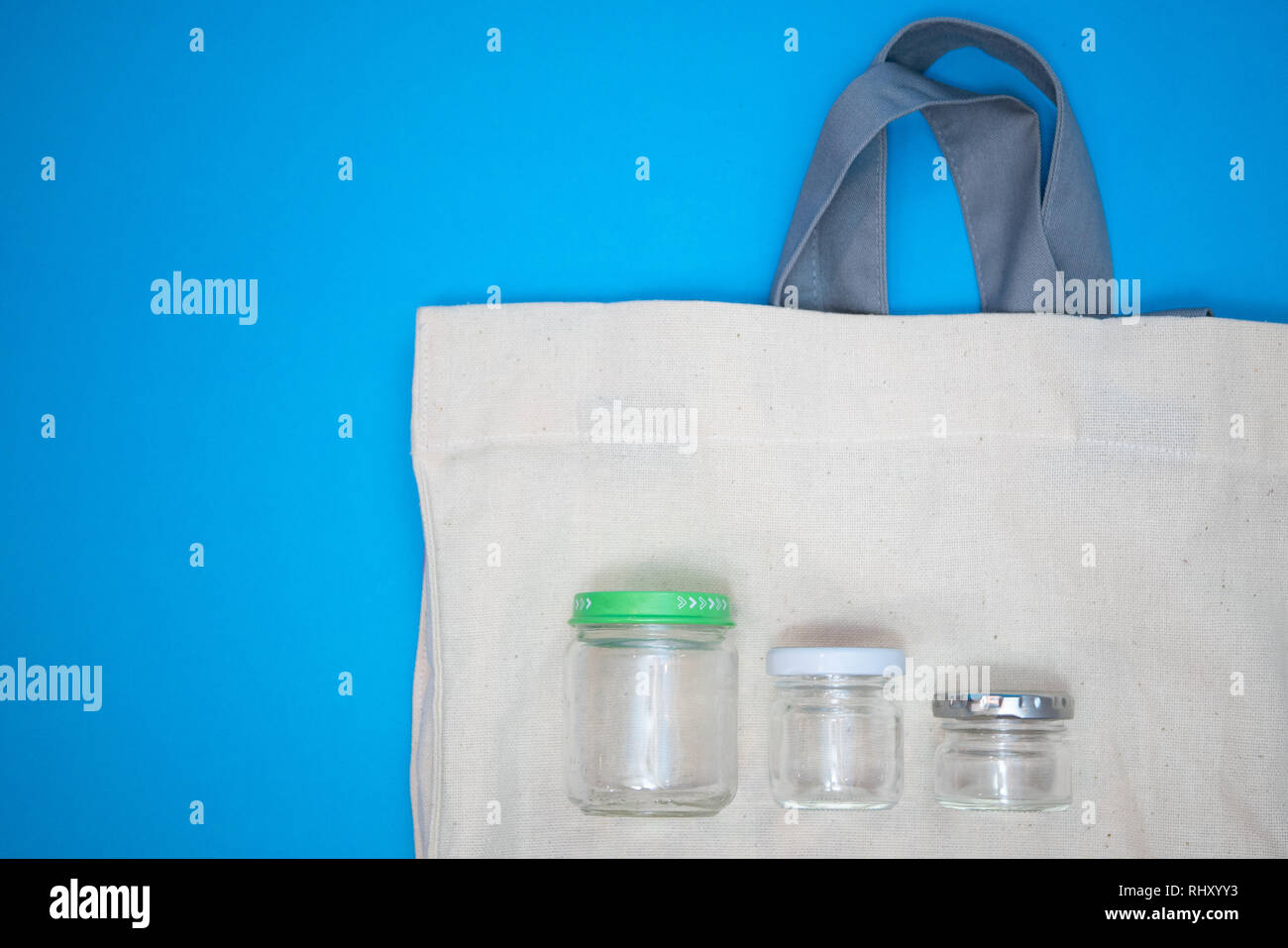 three small glass jars on linen bag. natural packing materials for food ...