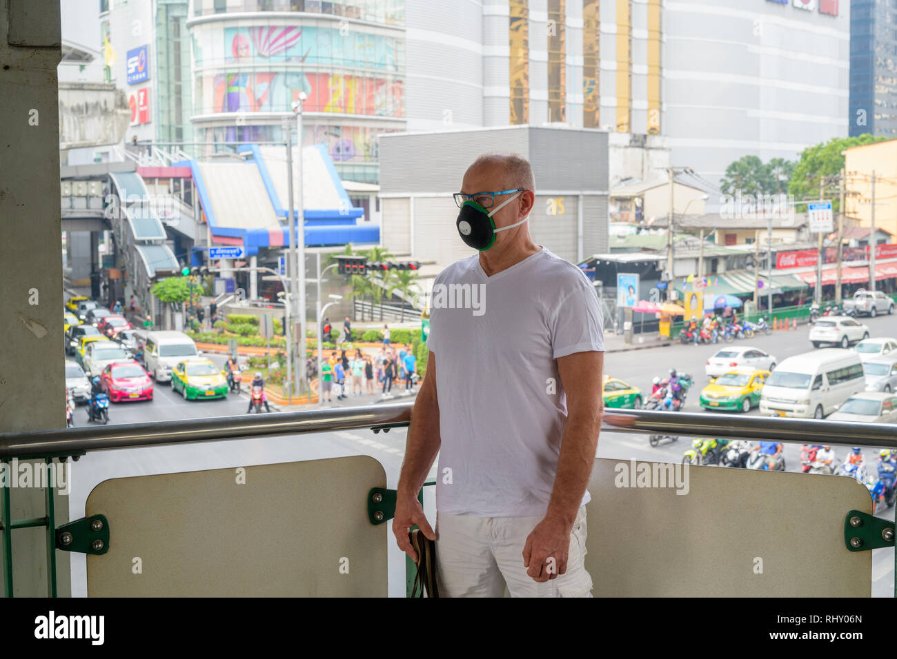 Senior man using face mask to protect from pollution smog in city Stock ...