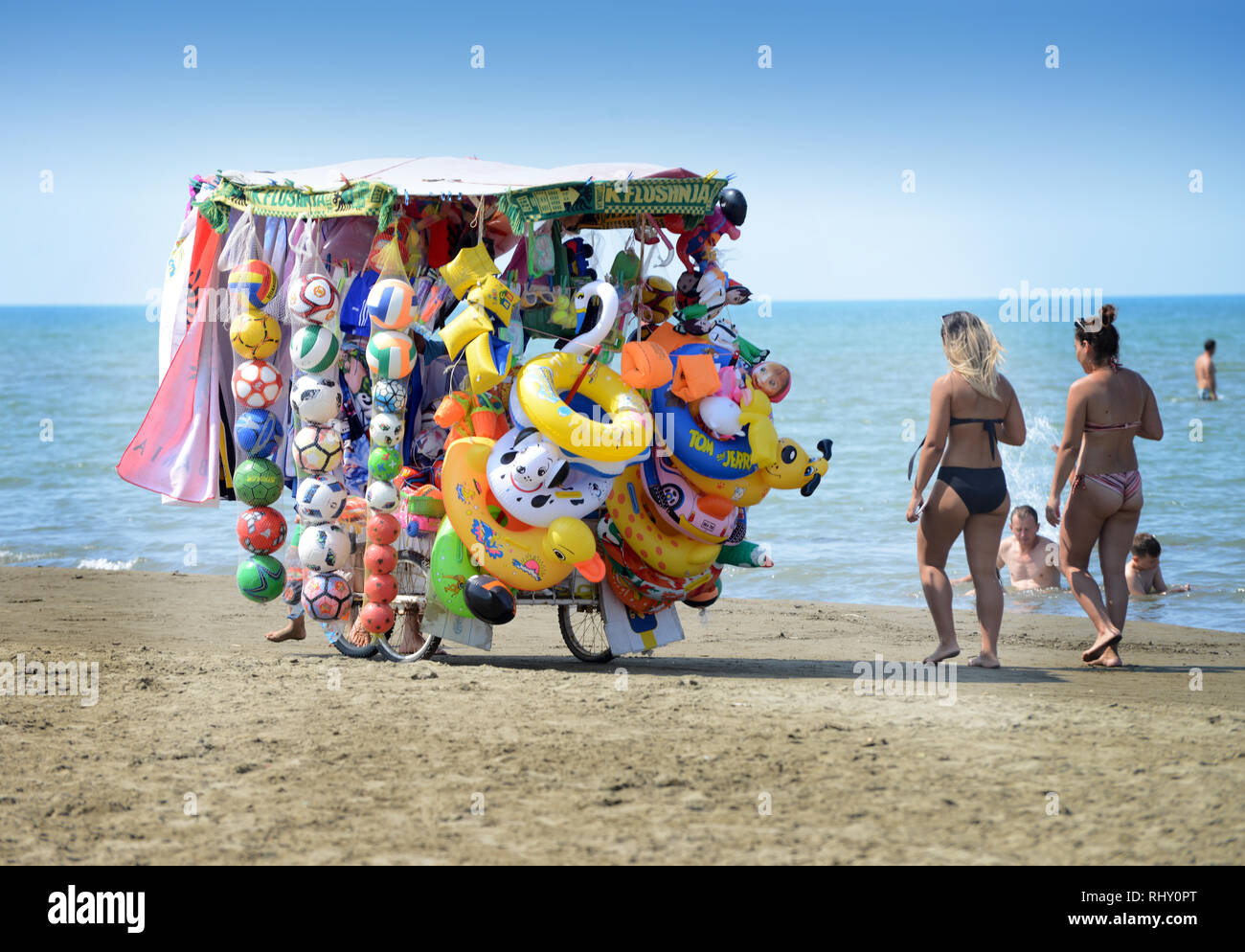 ALABANIA - A beach pedlar goes about his every day task of selling his ...