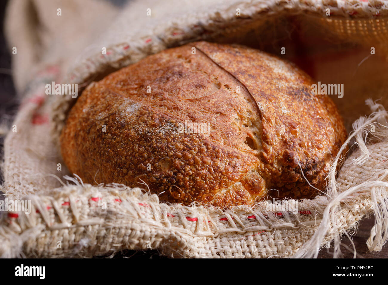 Traditional rye artisan bread in a bag. Still life on a wooden table ...