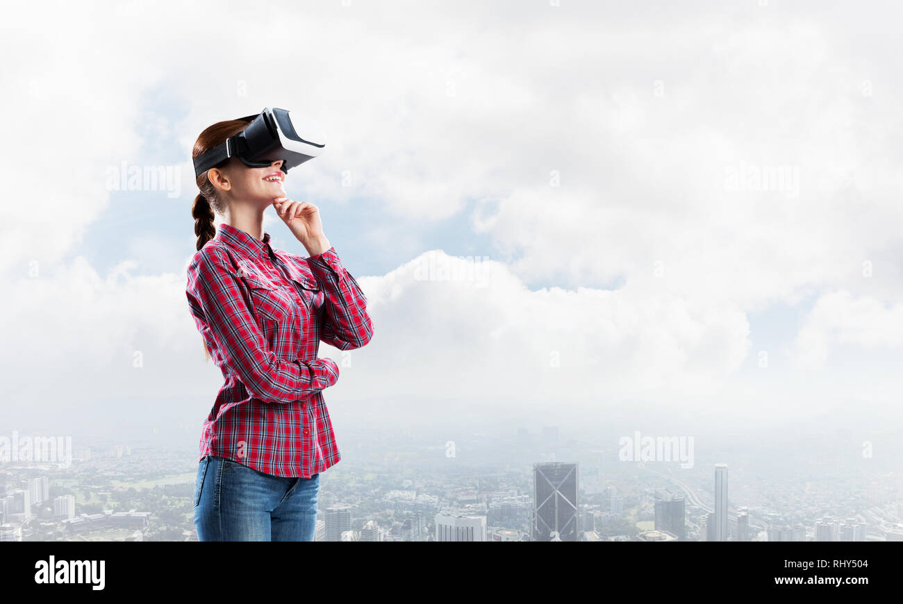 Girl in checked shirt wearing VR glasses experiencing another reality ...