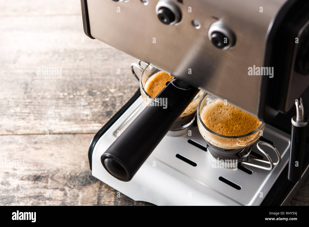 Fresh coffee in espresso coffee machine on wooden table Stock Photo - Alamy