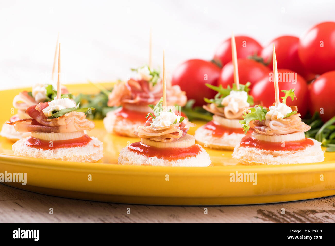 Delicious canapes with bacon and tomato on the plate - Image. Copy ...