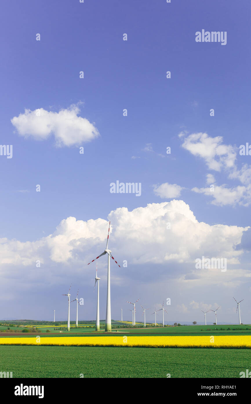 Wind farm with spinning wind turbines amidst agricultural land of ...
