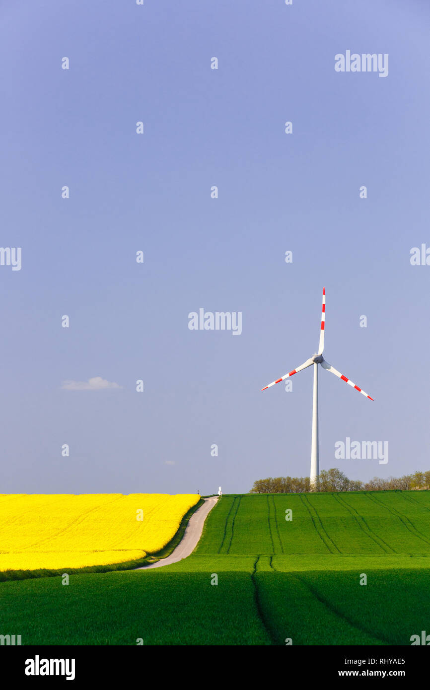 Wind farm with spinning wind turbine amidst agricultural land of ...