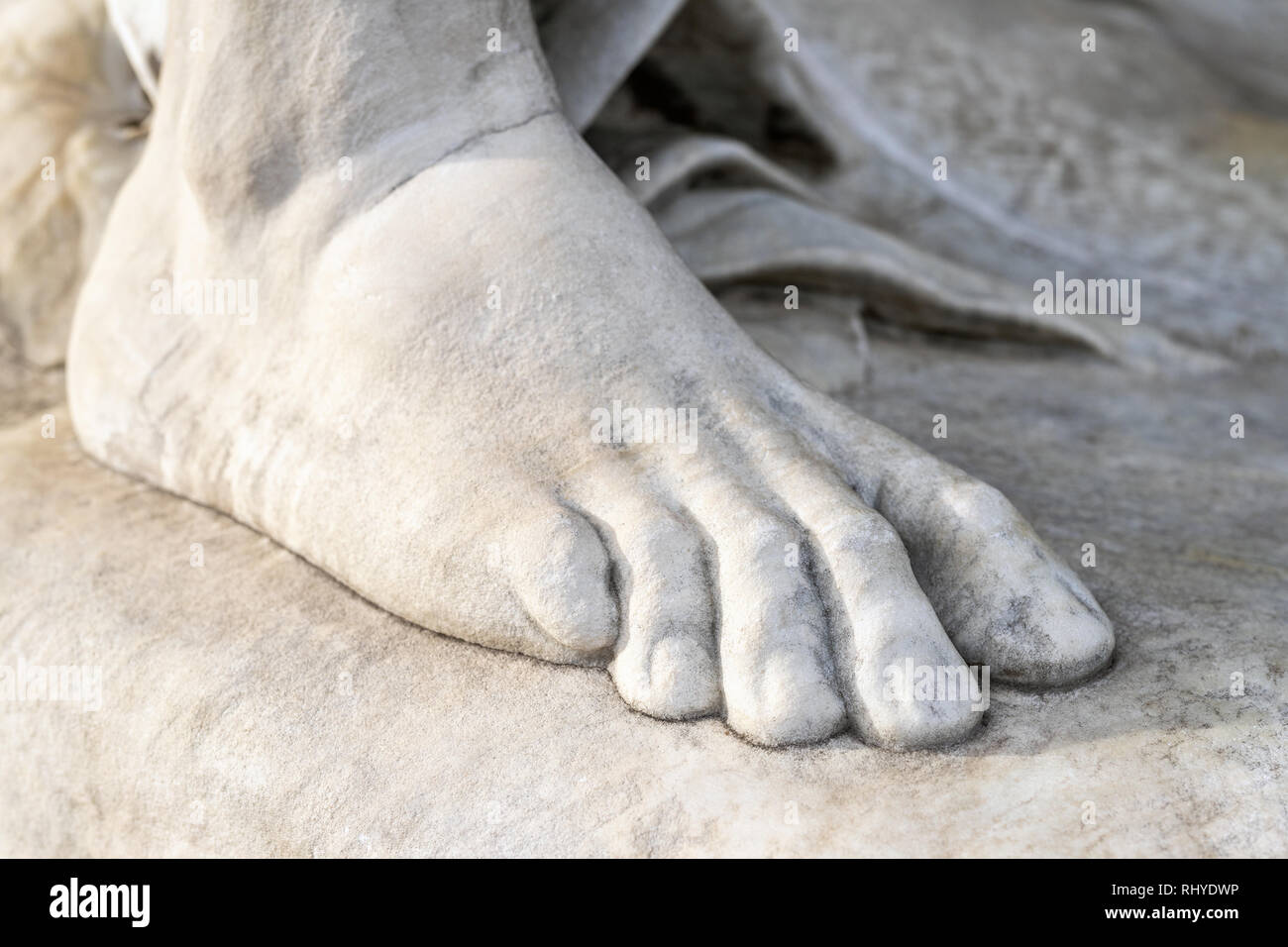 Part of leg of ancient marble statue. Close-up stone foot. Pedicure and ...