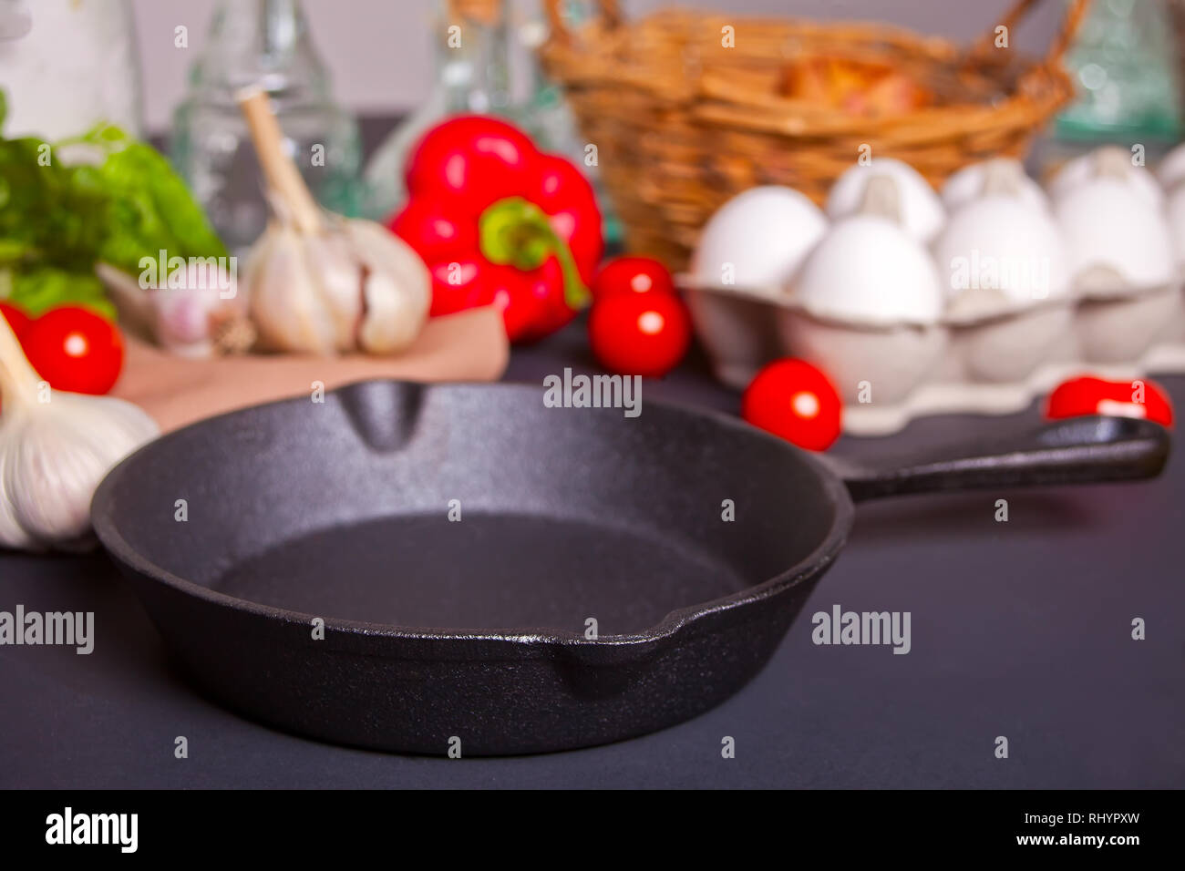 empty iron pan with fresh vegetables for cooking on dark table Stock ...