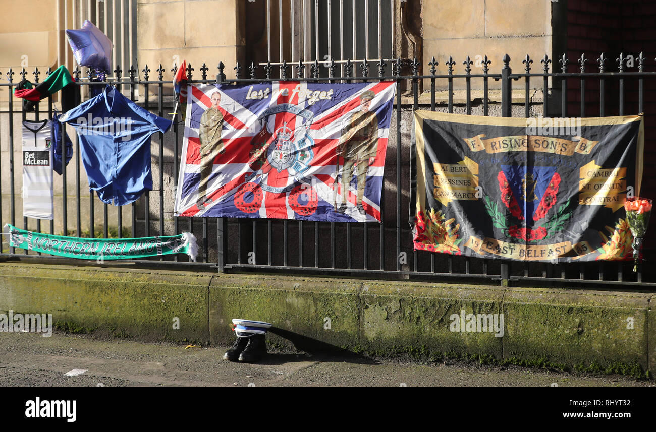 A loyalist flute band cap and boots are left in tribute at Cluan Place ...