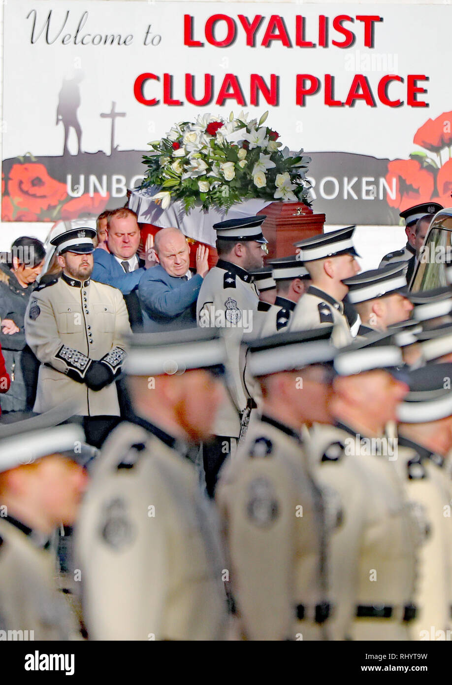 Ian Ogle's coffin is carried past a sign close to the scene of his ...