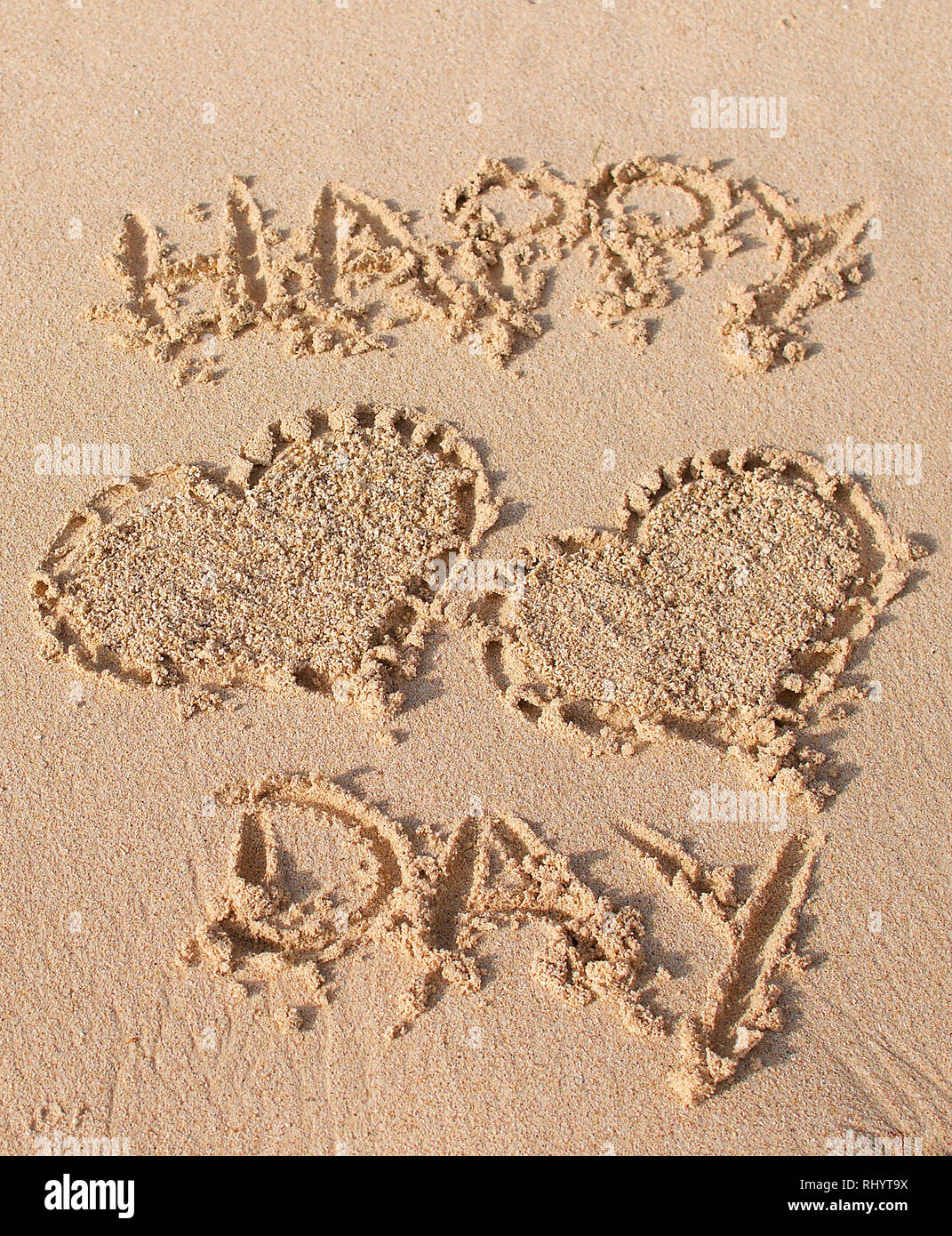 Text "Happy Love Day" with two heart shapes drawn at the beach Stock ...