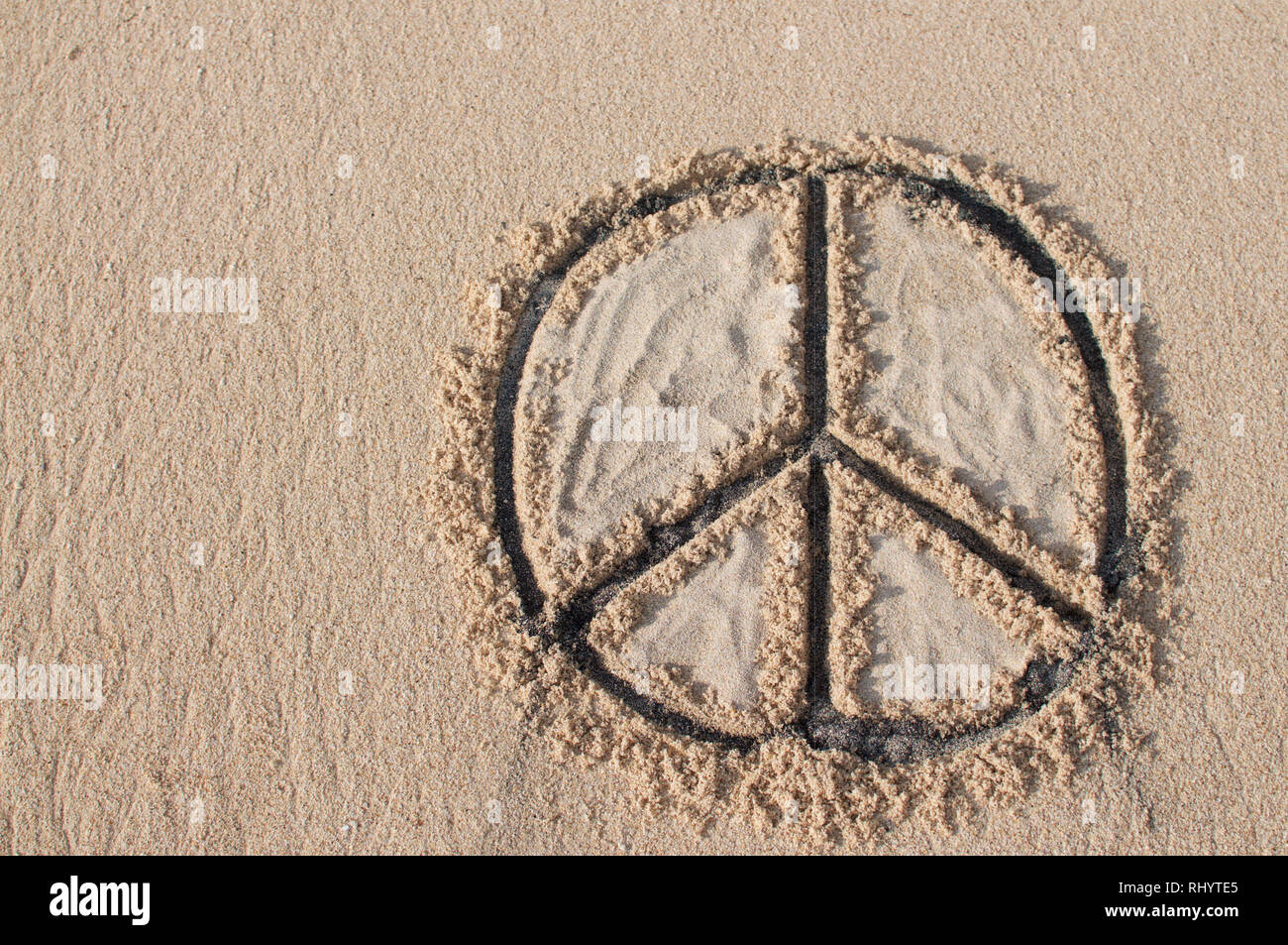 Peace symbol drawn at a beach and filled with white and black sand ...