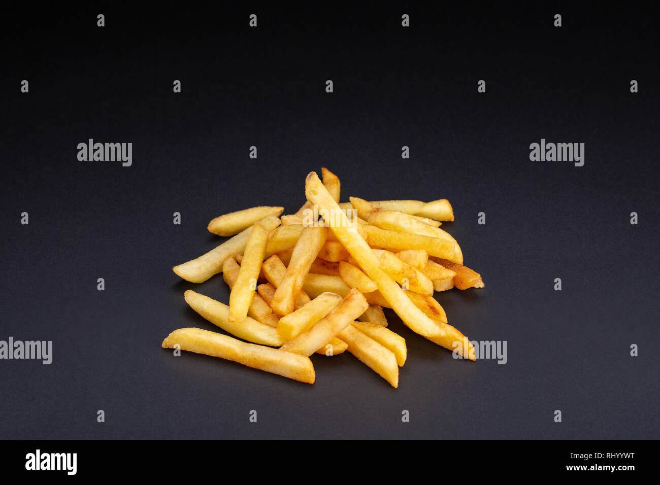 Pile of french fries over black background Stock Photo - Alamy