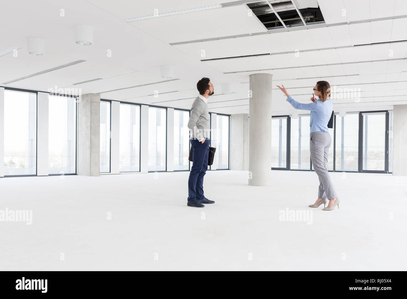 Professionals analyzing empty workspace in new office Stock Photo - Alamy