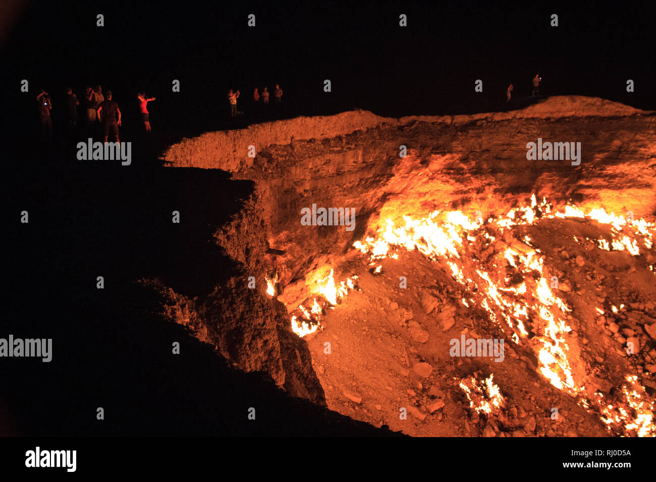 People looking down into, and posing for photos at The Darvasa Crater ...