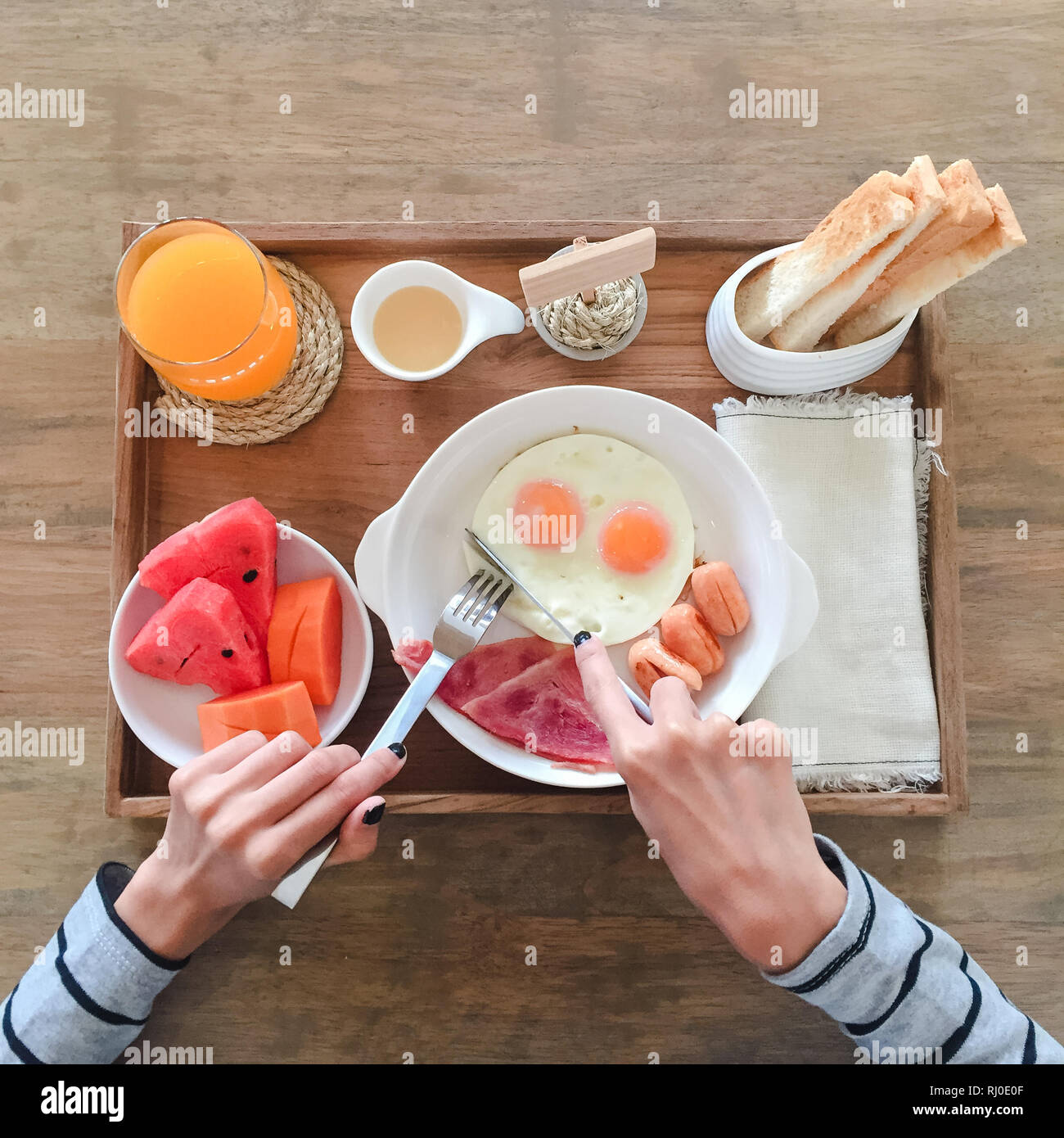 American breakfast. delicious breakfast for one. Woman hands cutting ...