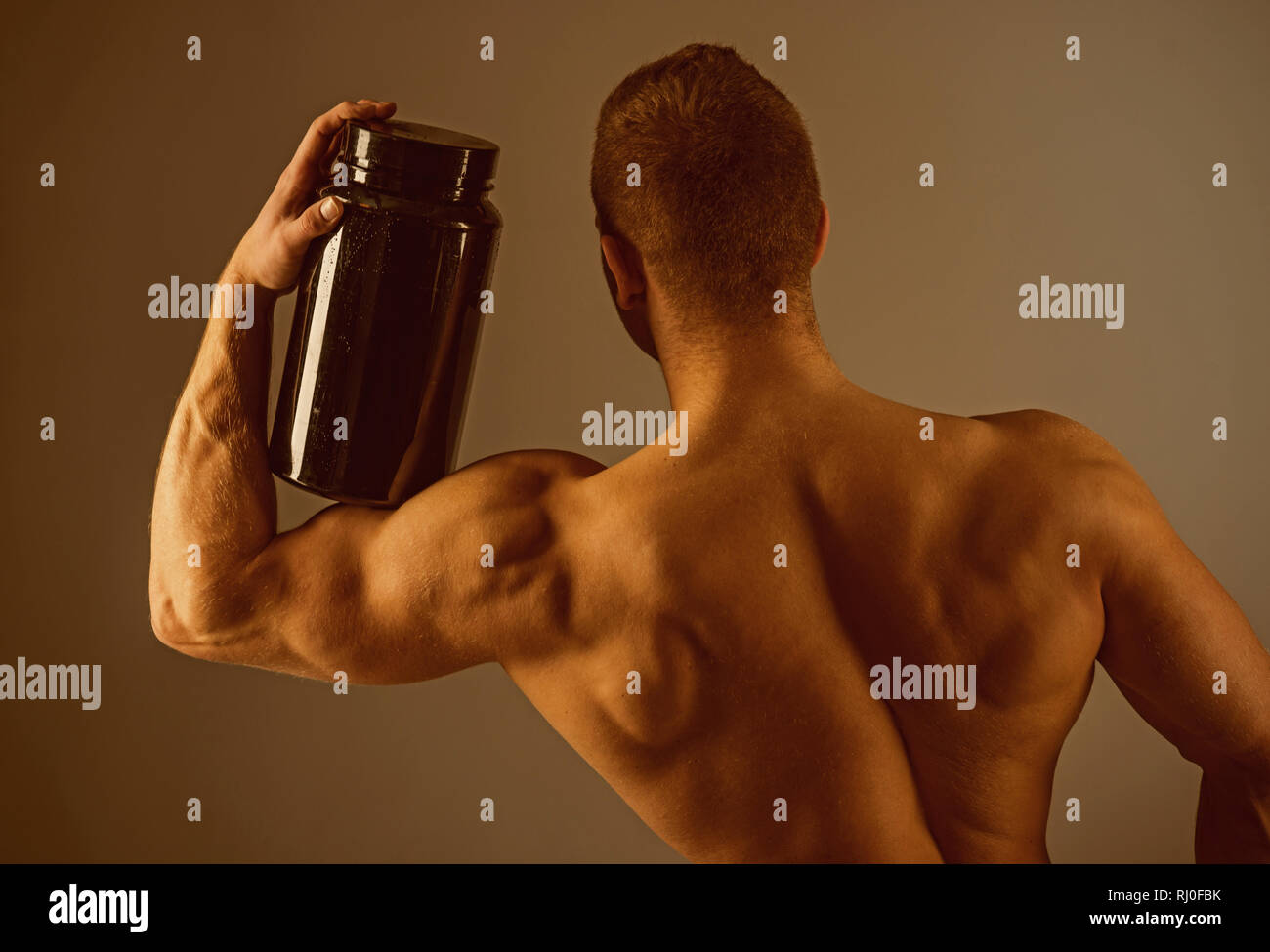 Taking vitamins for a healthy diet. Muscular man with vitamin ...