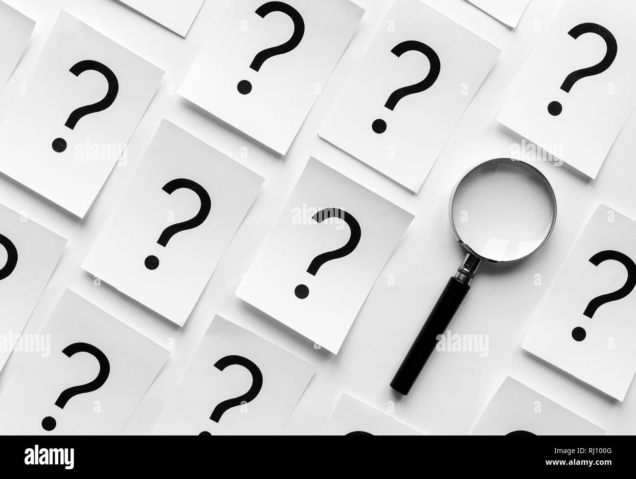 Diagonally orientated question marks printed on white paper cards and a ...