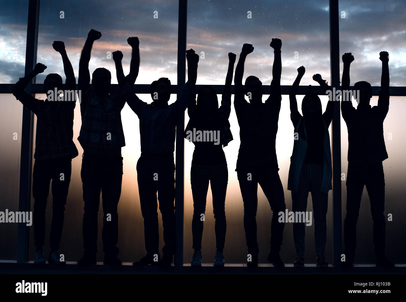 business team standing near the window with hands up Stock Photo - Alamy