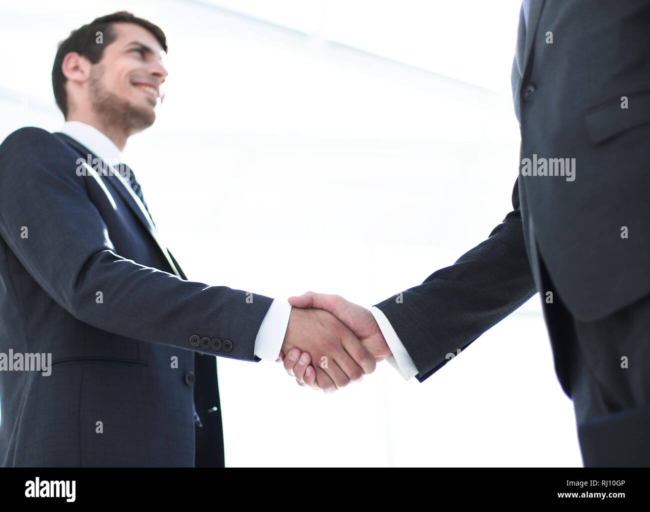 handshake of business partners on a light background Stock Photo - Alamy