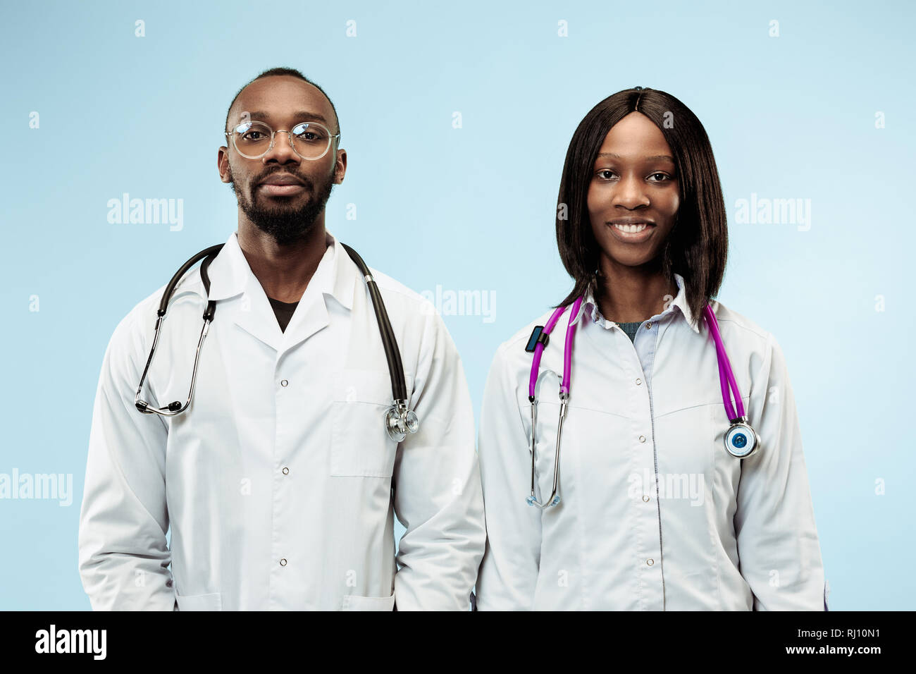 The female and male smiling happy afro american doctors on blue ...