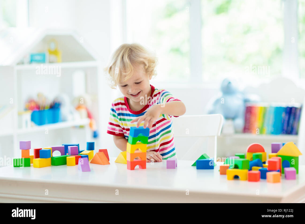 Kid playing with colorful toy blocks. Little boy building tower of ...