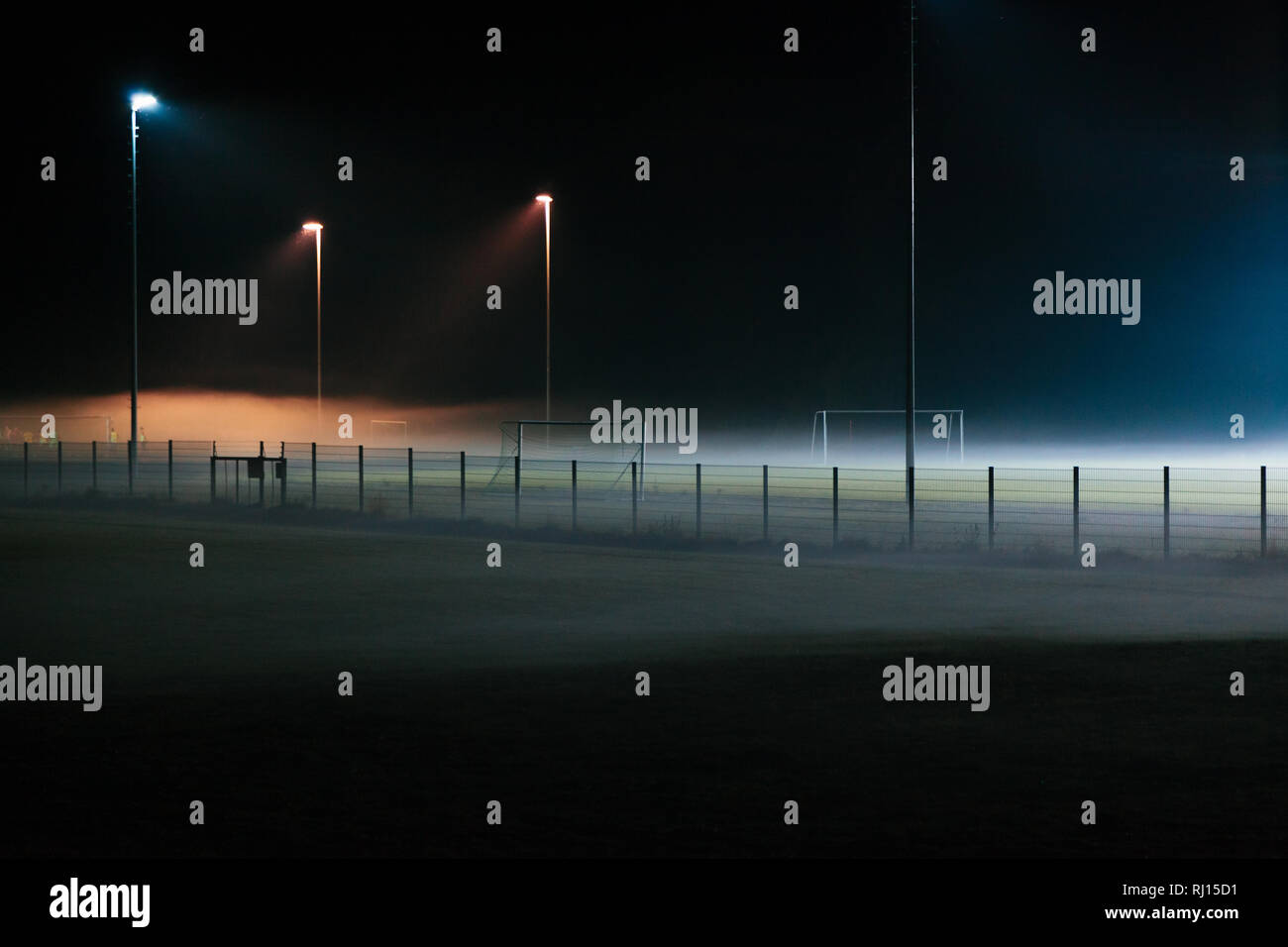 Lonely football field covered by fog at night only illuminated by ...