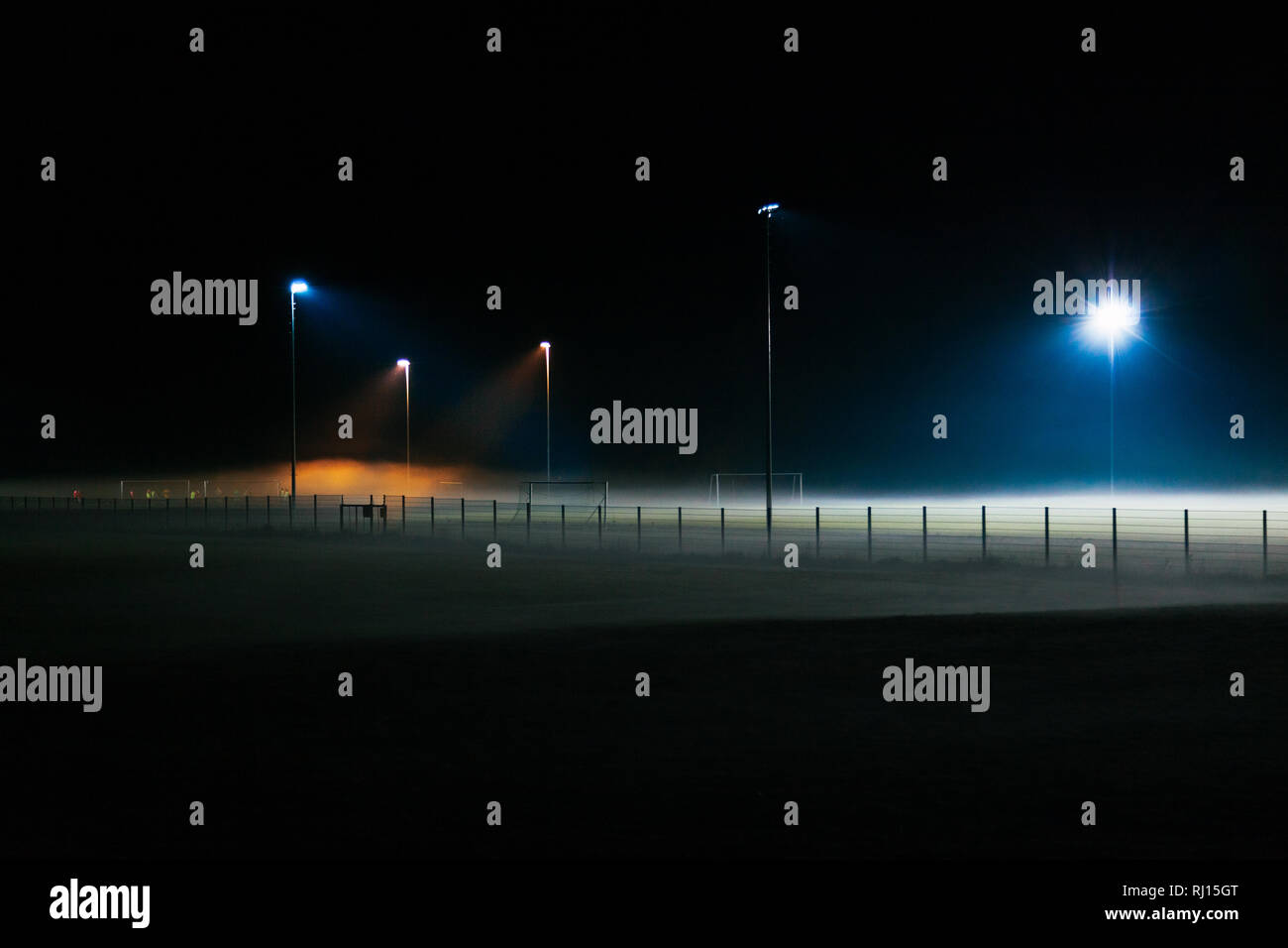 Lonely football field covered by fog at night only illuminated by ...