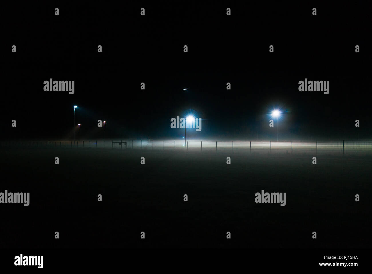 Lonely football field covered by fog at night only illuminated by ...