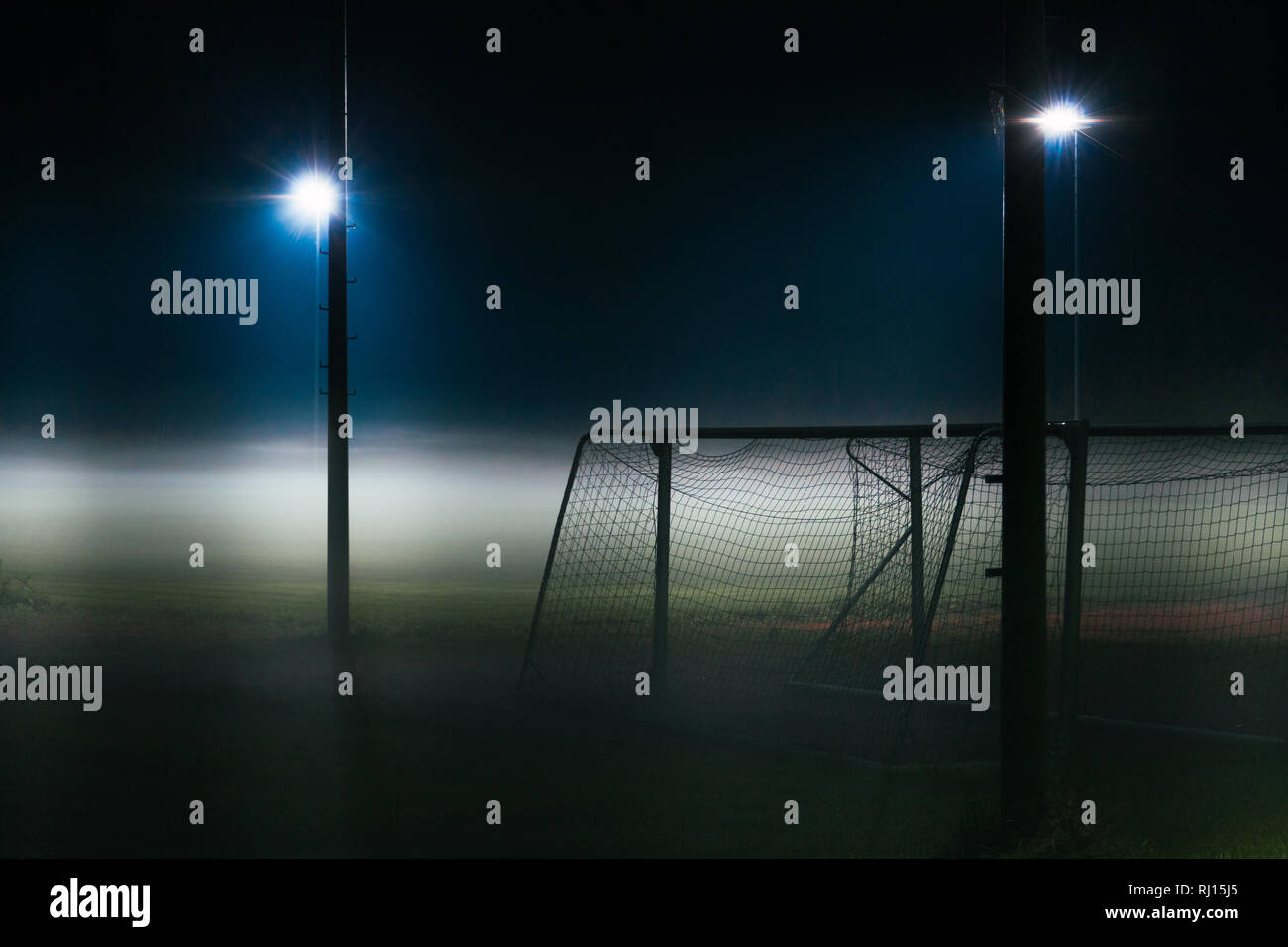 Lonely football field covered by fog at night only illuminated by ...