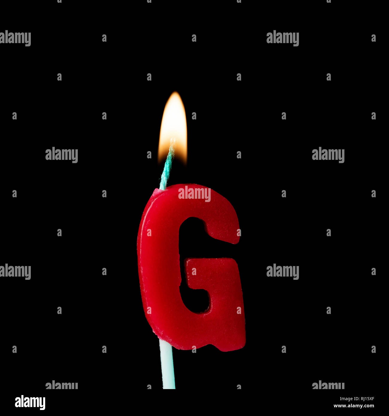 Letter G celebration birthday candle against a black background Stock ...