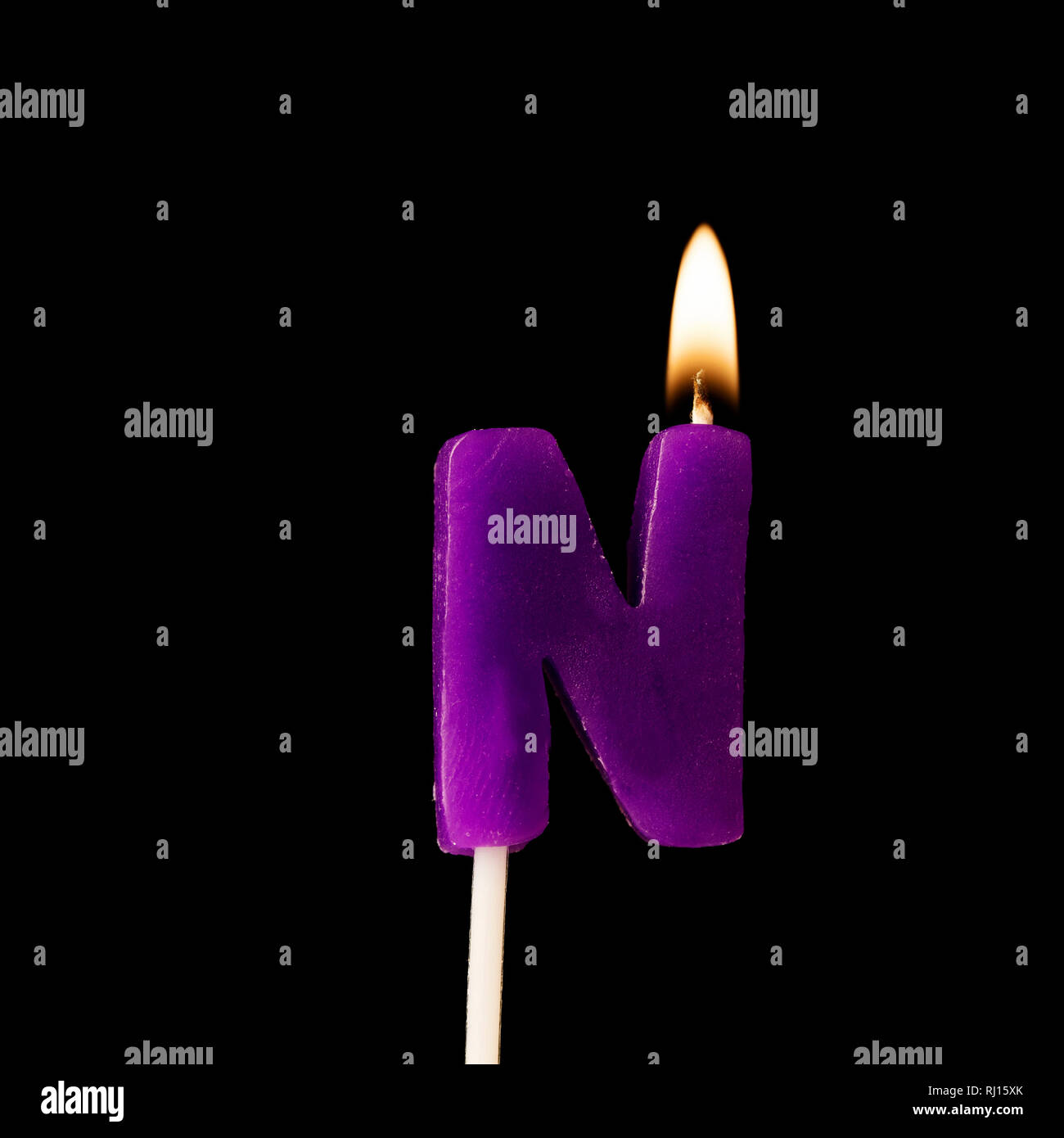 Letter N celebration birthday candle against a black background Stock ...