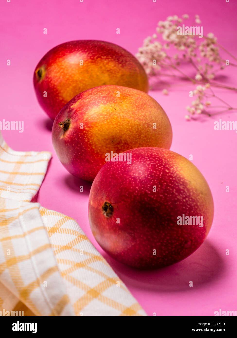 3 ripe mangoes on pink background Stock Photo - Alamy