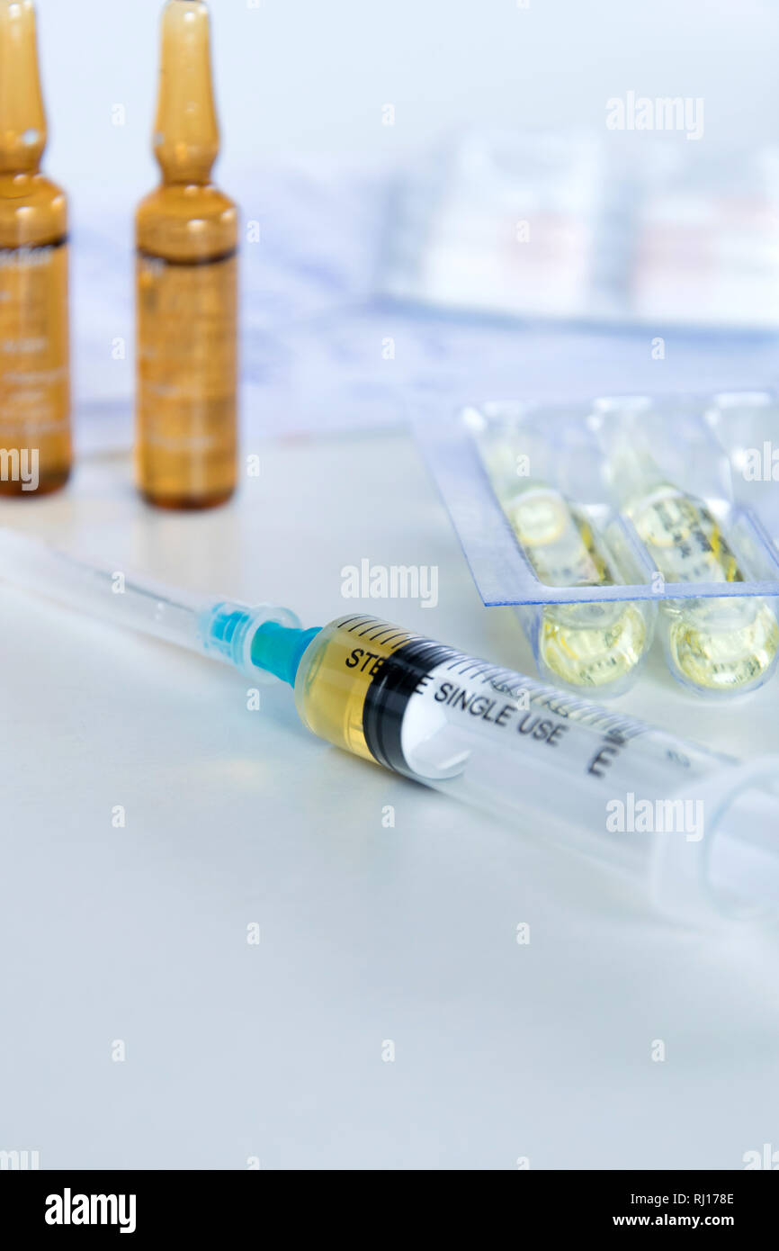 Medical syringe with injection solution, medicine pills and capsules on ...