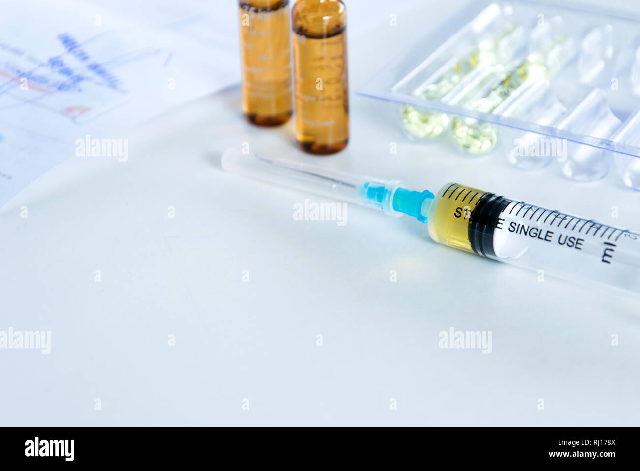 Medical syringe with injection solution, medicine pills and capsules on ...
